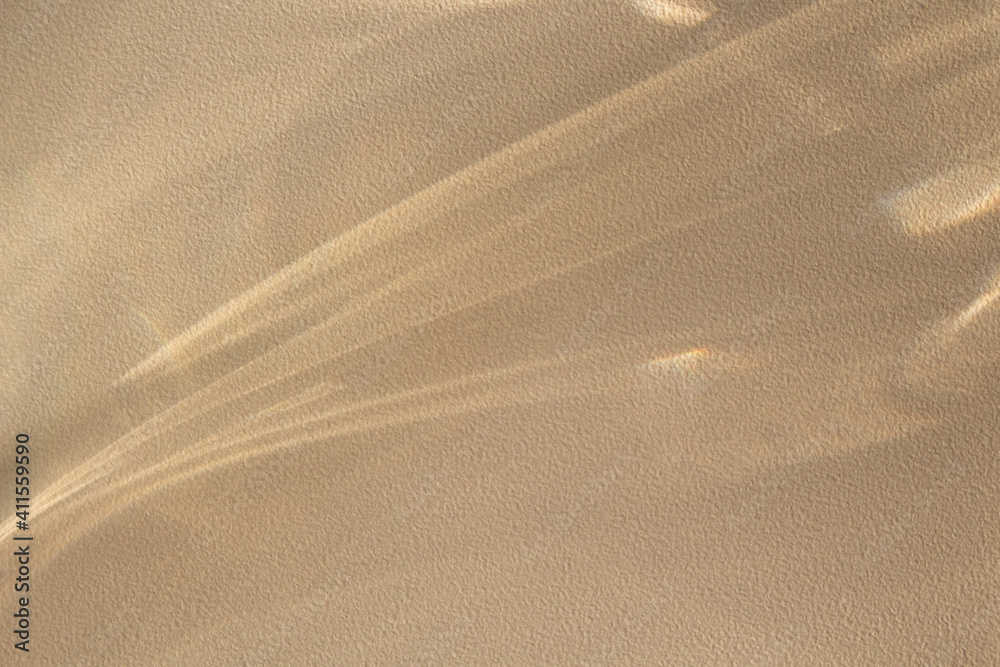 Background with shining lines of natural light on a sand color textured ...