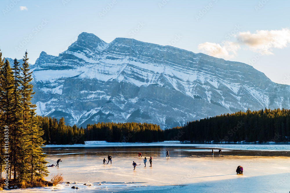 Beautiful view of people ice-skating on the Two Jack Lake in Banff ...