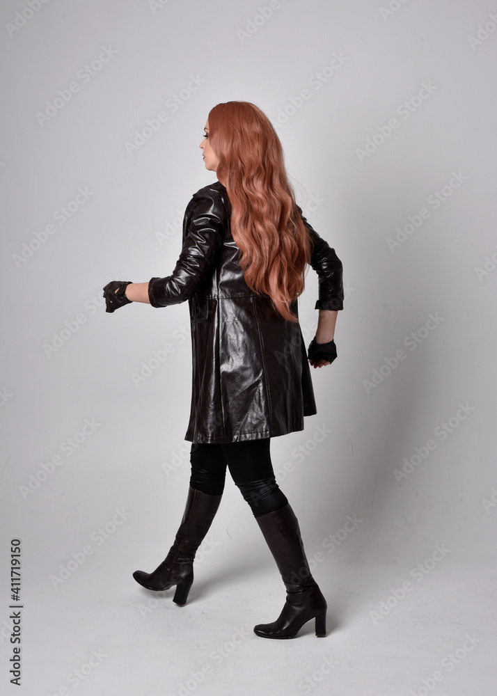 full length portrait of girl with long red hair wearing dark leather ...