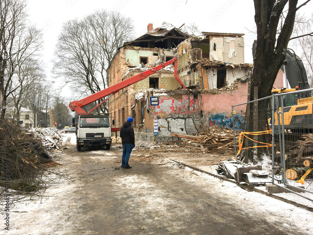 Demolition of an old, dilapidated residential building on a city street ...