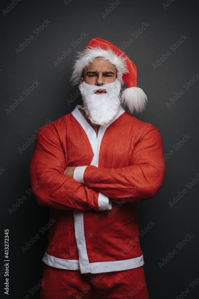 Muscular man in Santa hat at grey background in studio. Handsome man in ...