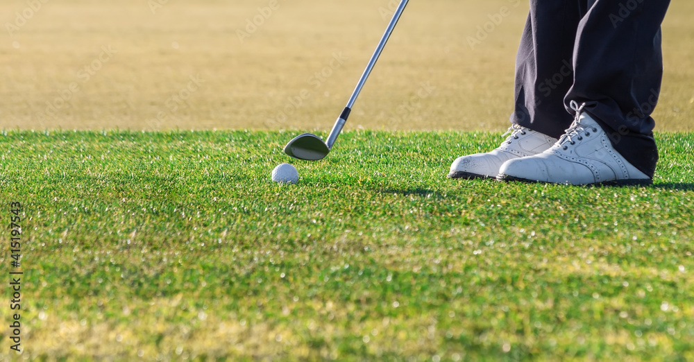 Zoomed in shot of a ball that is placed on a golf course and a golfer ...