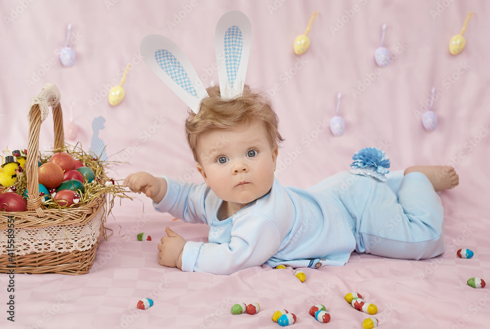 Cute baby wearing a blue bunny rabbit costume lying on his stomach near ...