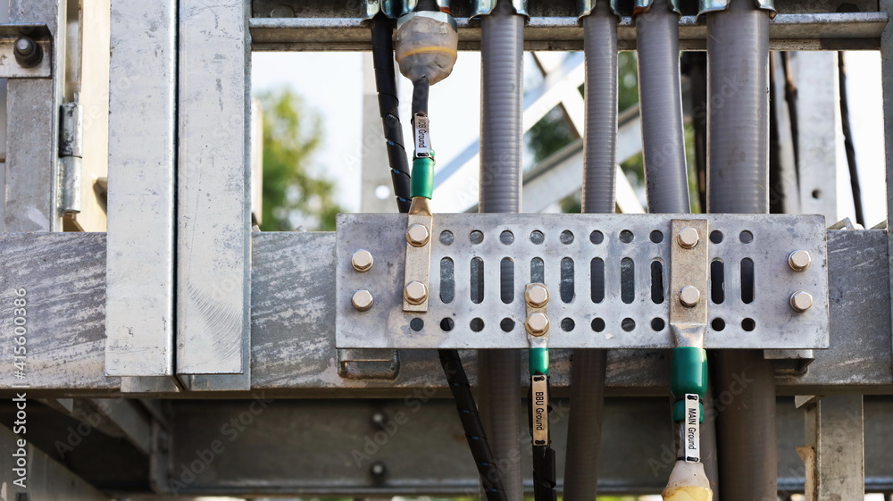 Gray ground bar with cable. Grounded metal panel on telecommunication ...