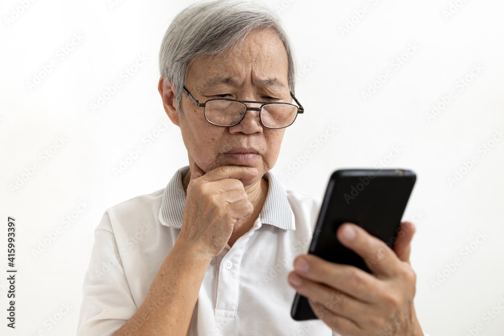 Confused asian senior woman with puzzled looks holding smartphone ...