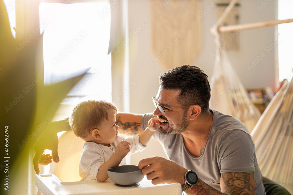 Single dad feeding his baby Stock Photo | Adobe Stock