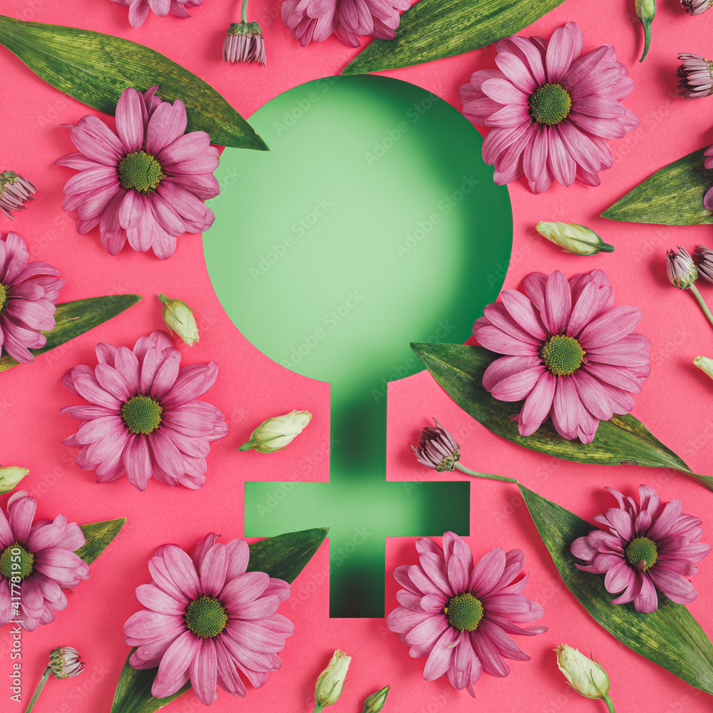 Female symbol with fresh spring gerbera flowers and leaves against two ...