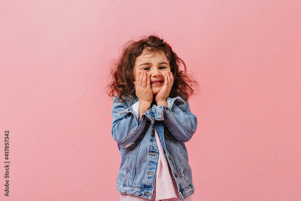 Adorable cute kid in denim jacket touching face. Smiling preteen girl ...