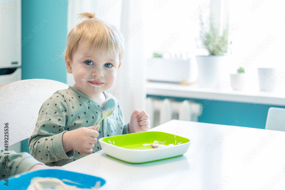Cute little kid boy hungry eating healthy food in kitchen at home ...