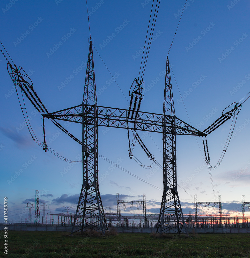 High voltage electric pole and transmission lines in the evening ...