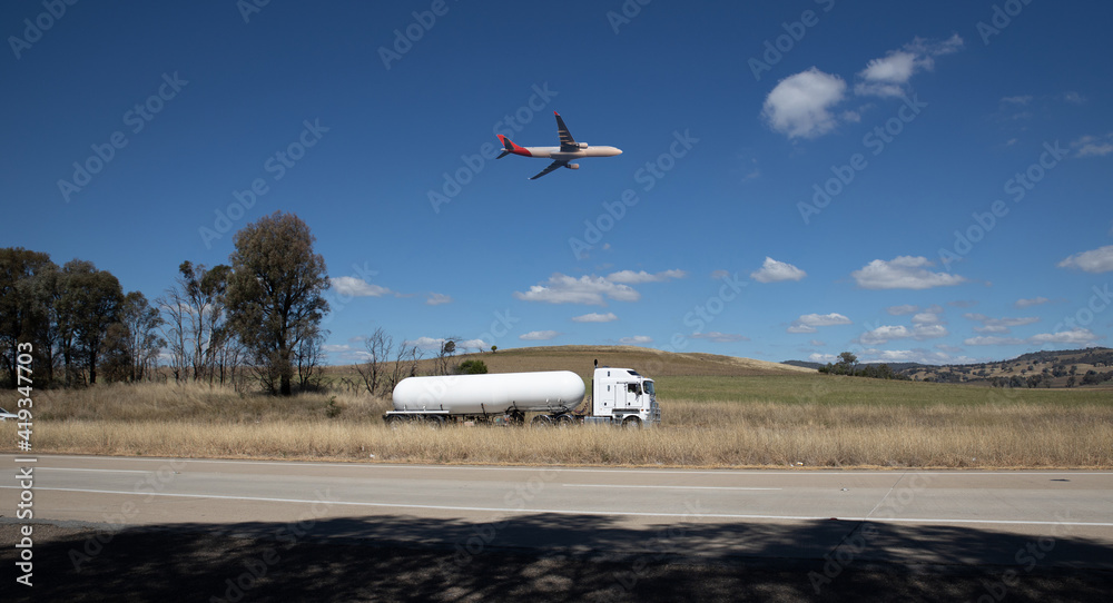 Truck on a freeway with plane flying overhead in Australian Country ...