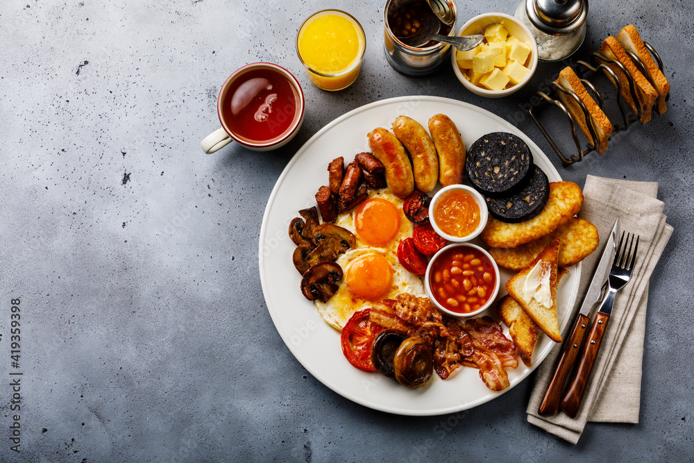 Full fry up English breakfast with fried eggs, sausages, bacon, black ...
