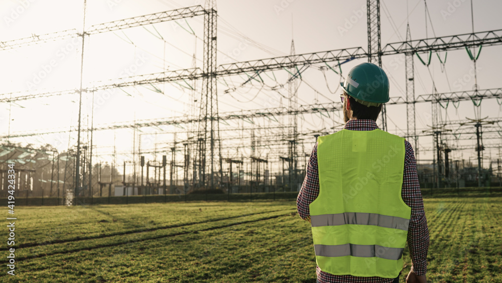 Electrical engineer wearing a helmet and safety vest working with ...