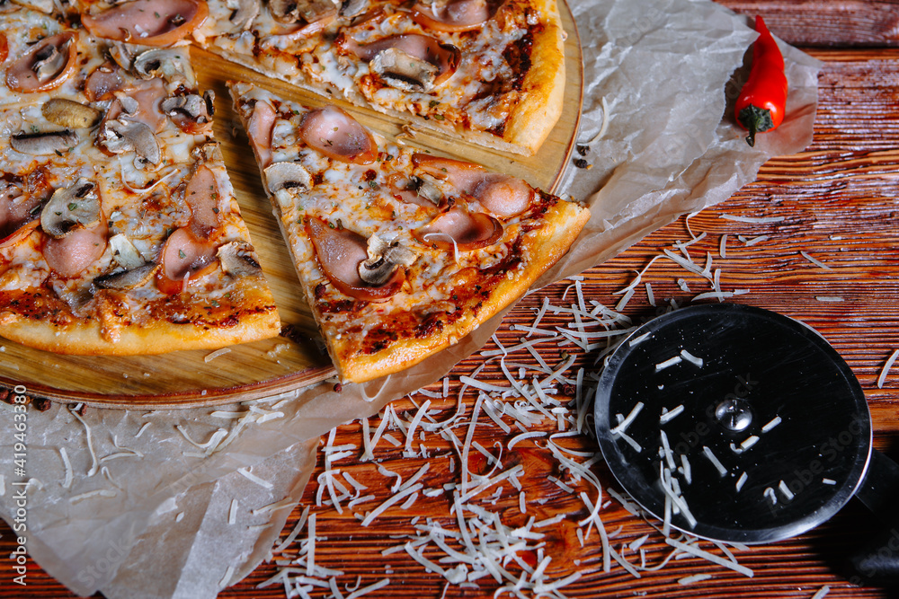 The pizza is on the kitchen table with the ingredients scattered around ...