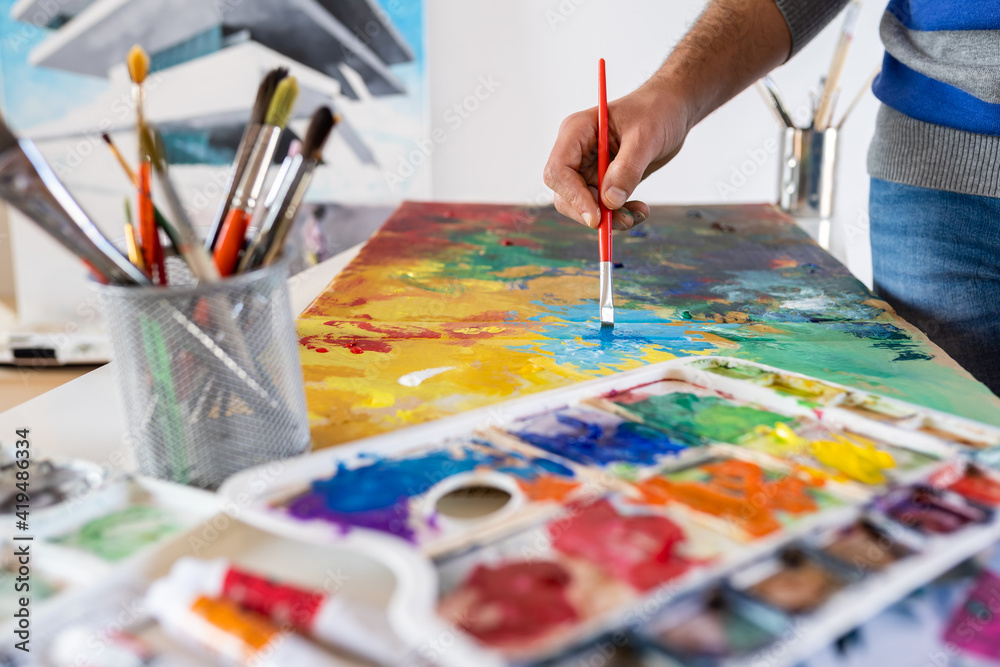 Crop unrecognizable male painter using professional brush during ...