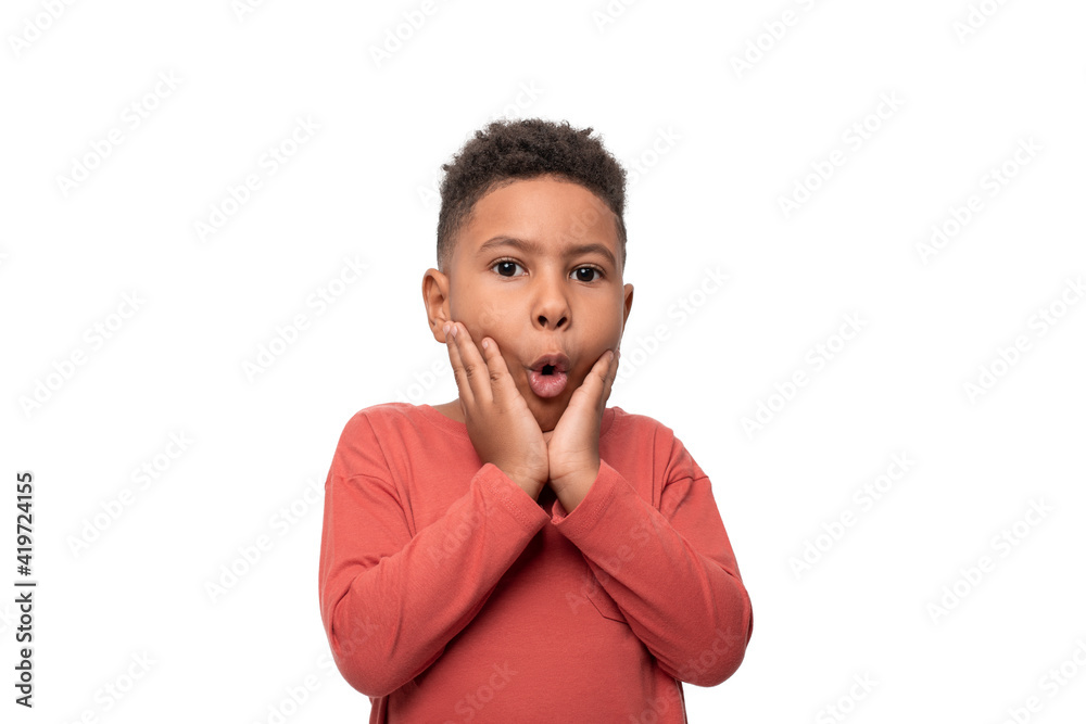 Little dark skinned African boy wearing pink shirt holding his cheeks ...