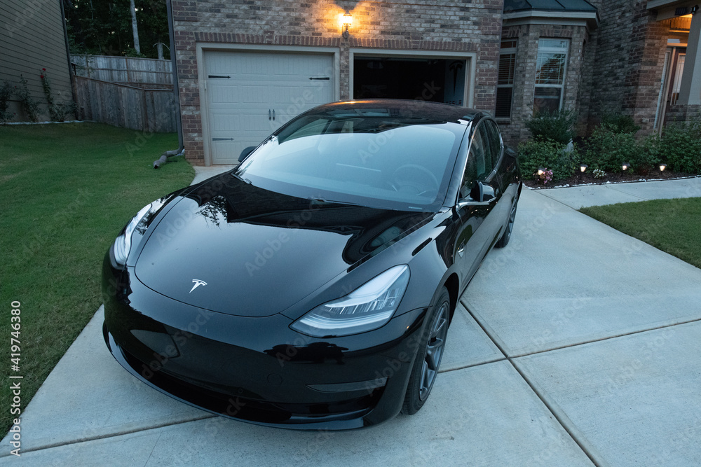 Black Tesla Model 3 Parked in the Driveway in front of a House Stock ...