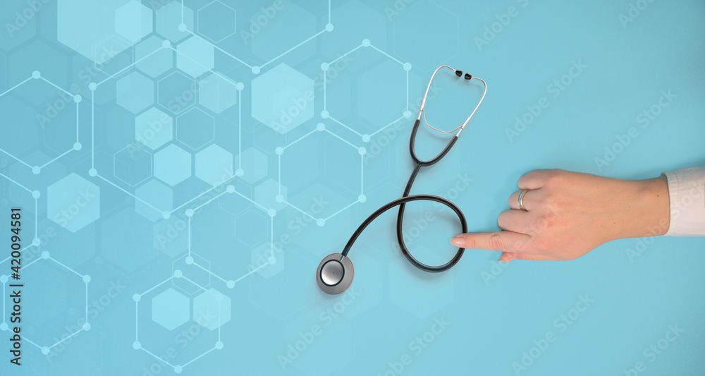 Pastel blue medical background. Female hand pointing at stethoscope on ...
