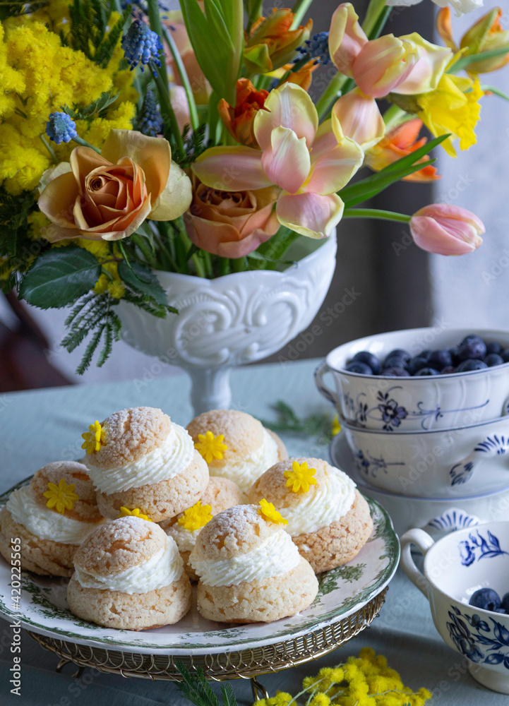 Choux Buns with Craquelin (crispy cream puffs) filled cream on a table ...