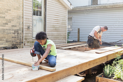 Tween girl using power tools to help build an outdoor deck Stock Photo ...