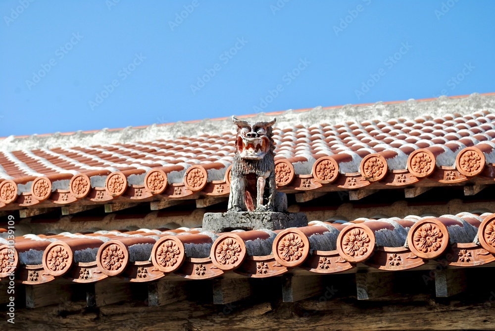 Okinawa shisa sits on a traditional Okinawan red ceramic tile roof ...