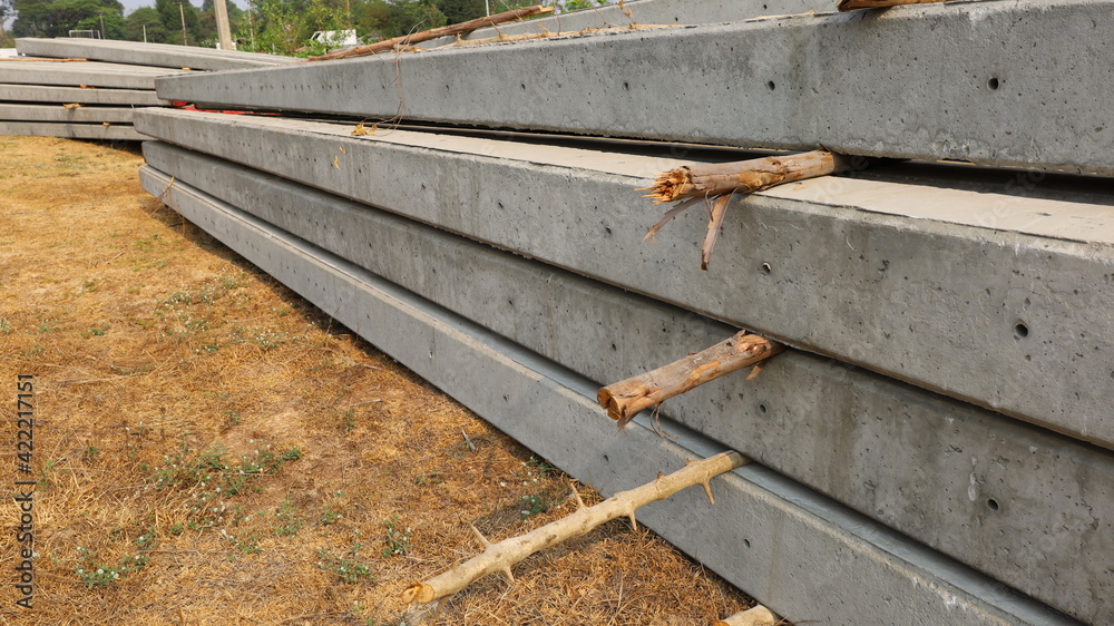 Piles of electric poles and sleepers. Concrete power poles stacked on ...