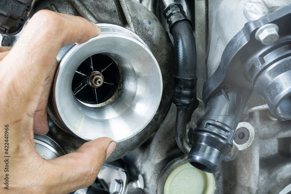 Turbo charger on car engine with hand of mechanic while inspecting the ...