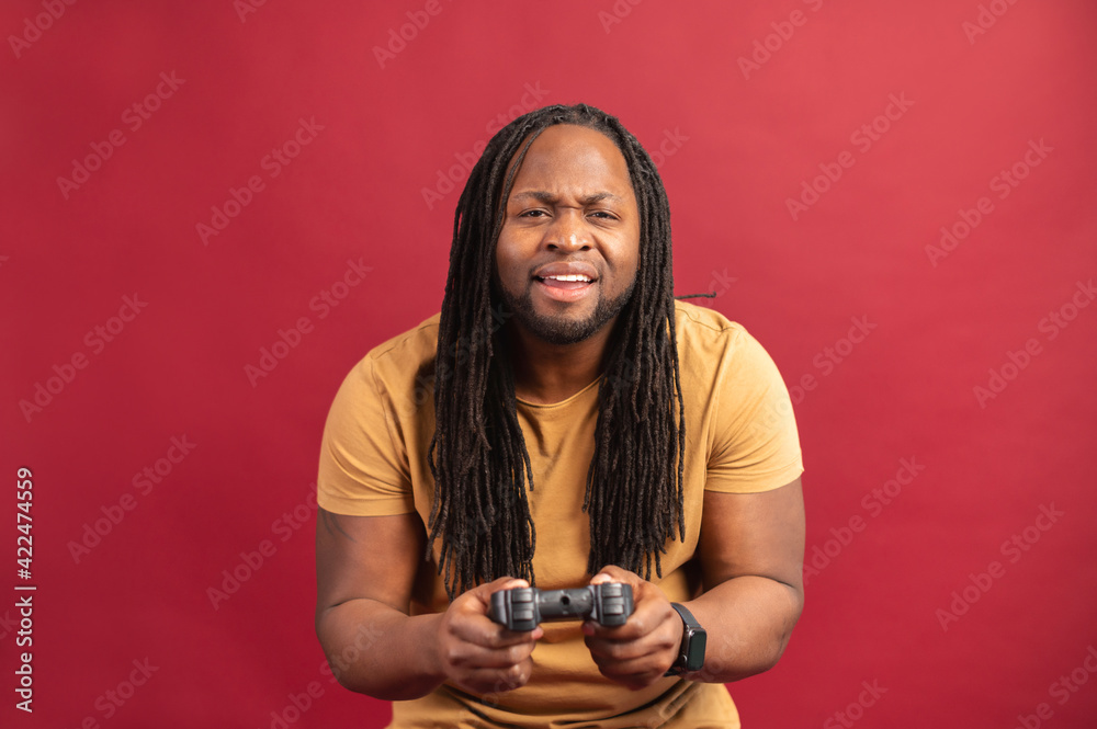 Confused young African American man with dreadlocks isolated over red ...