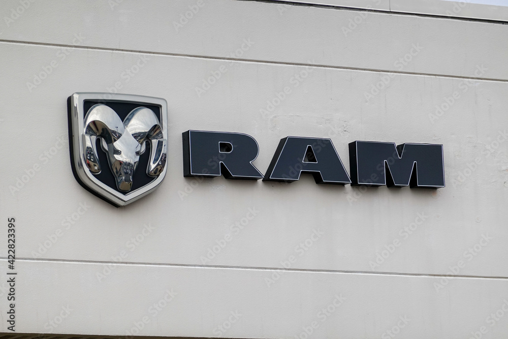 The word Ram in gray letters and a Dodge logo is seen on the white ...