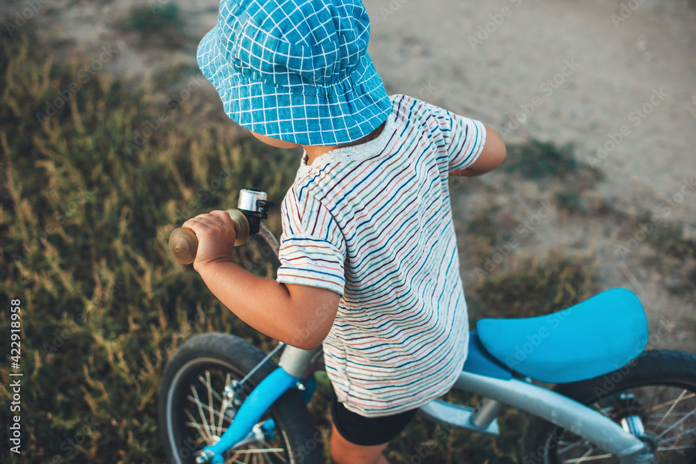 Upper view photo of a caucasian boy with blue hat riding a bike in the ...