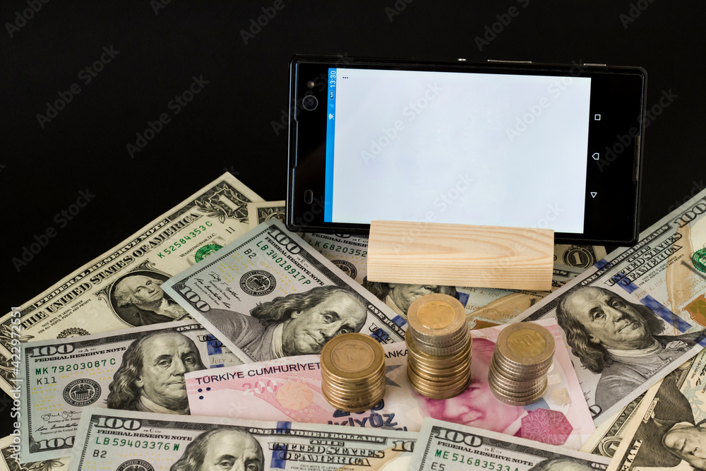 Turkish Money and American Dollar Bills on black background with smart ...
