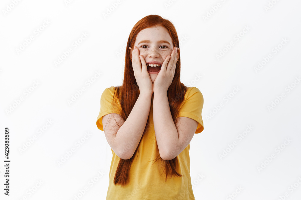 Surprised ginger girl with freckles checking out something awesome ...