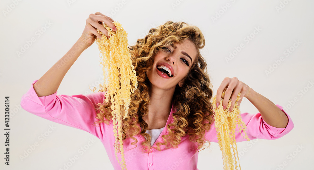 Sexy woman with spaghetti in hands. Smiling girl with curly hair holds ...