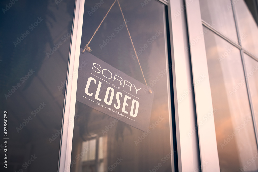 Sorry we are closed sign board through the glass of coffee shop or ...