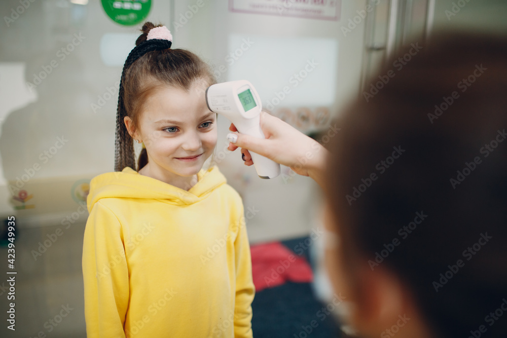 Child head temperature measurement by laser thermometer at kindergarten ...