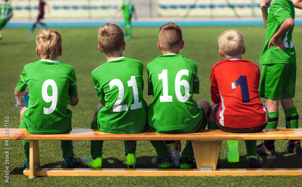 Group of school boys in a team. Kids sitting on substitutes' bench ...