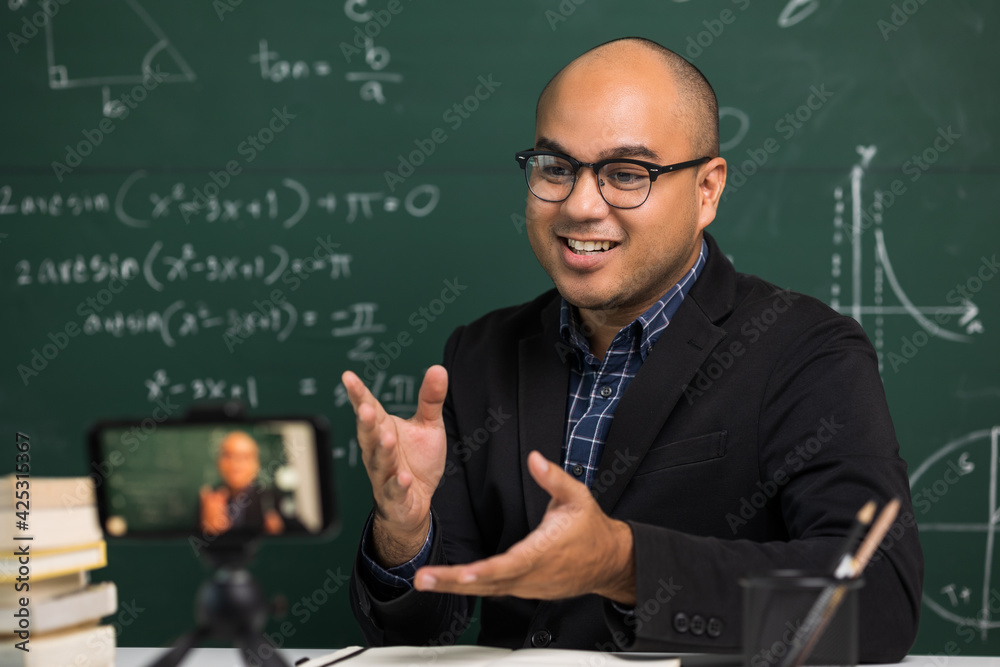 Indian young teacher man sitting teaching online video conference live ...