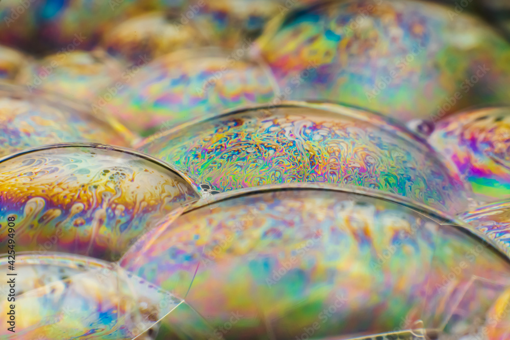 The colorful close-up surface of a soap bubble with weird psychedelic ...