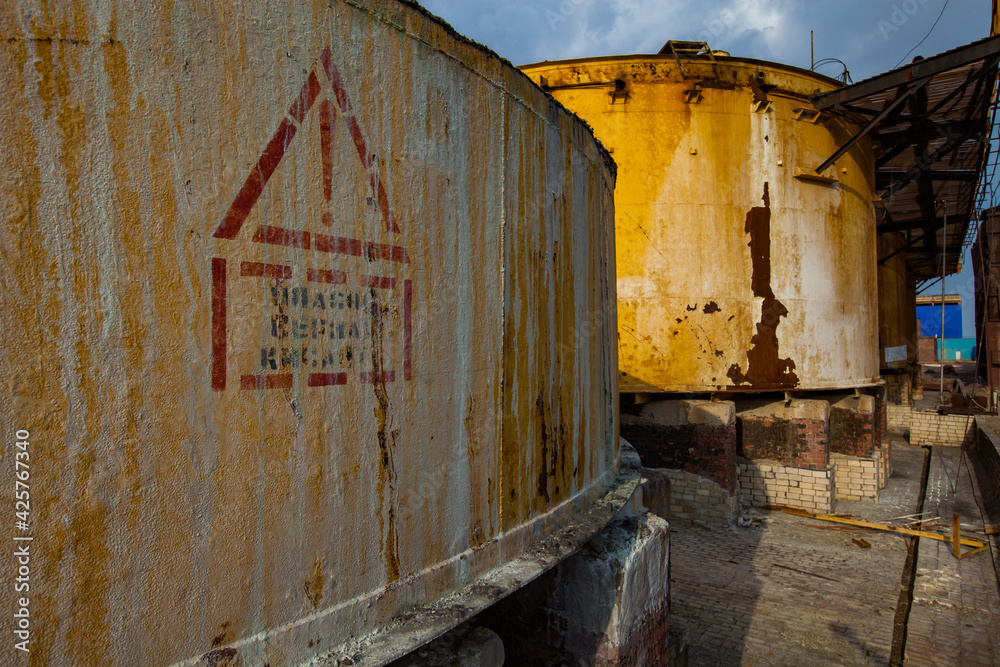 Demolition of outdated Soviet sulfuric acid plant. Old rusted yellow ...