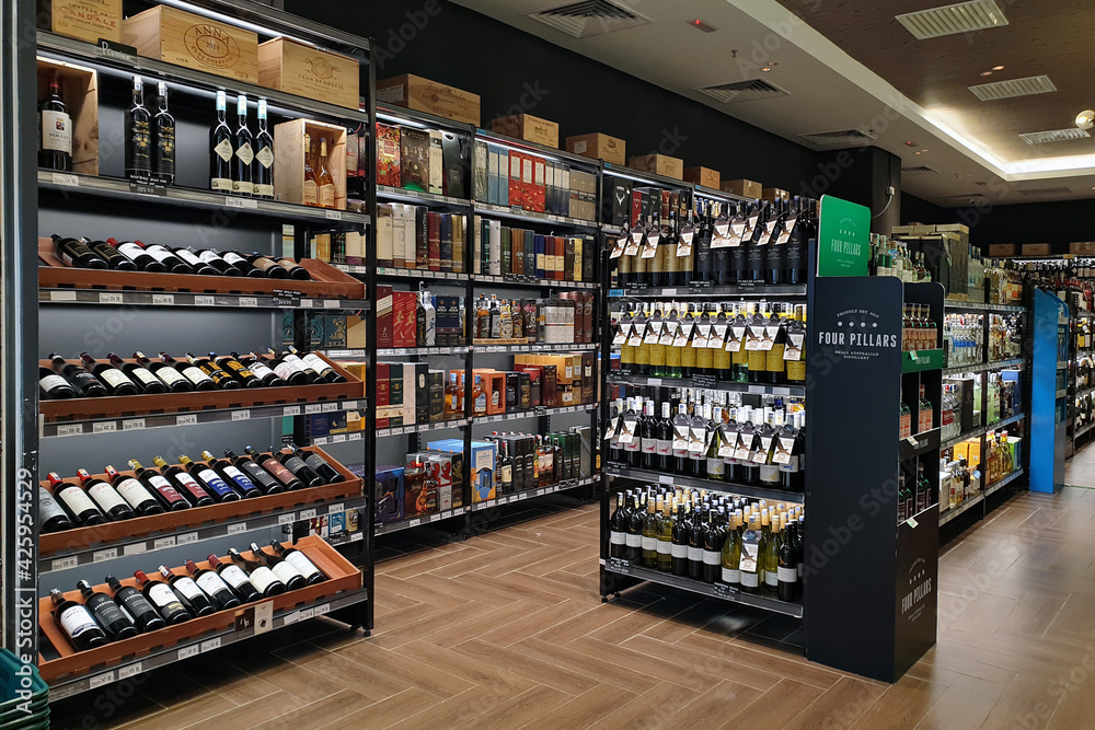 An assortment of wine and hard liquor bottles stacked neatly on store ...