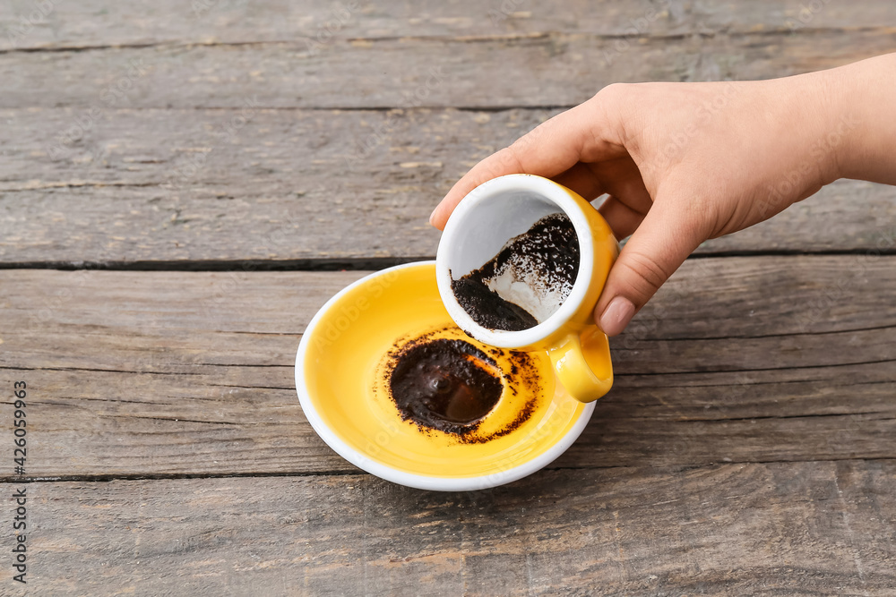 Woman reading coffee grounds at wooden table Stock Photo | Adobe Stock