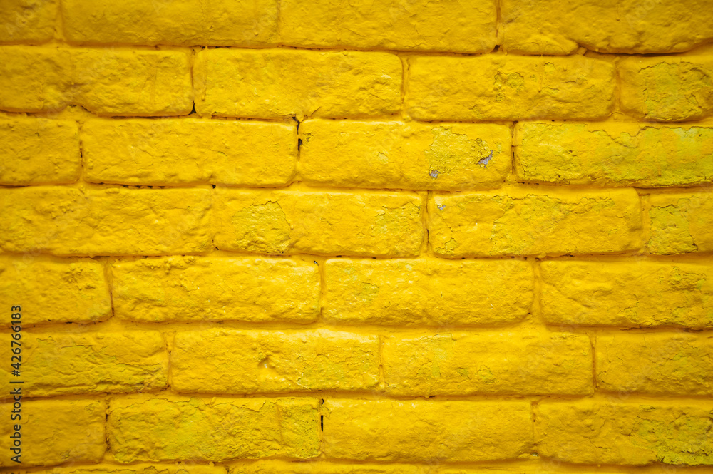 Yellow abstract background. The wall is made of old yellow brick. The ...