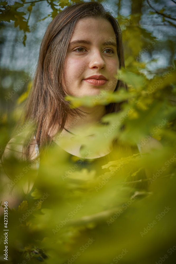 Light-skinned young woman with long hair, black top and necklace among ...