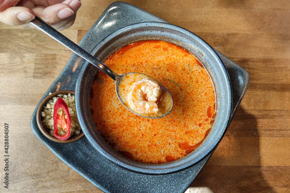 Bowl wuth a hot delicious tom yum soup and a spoone with a shrimp. の ...