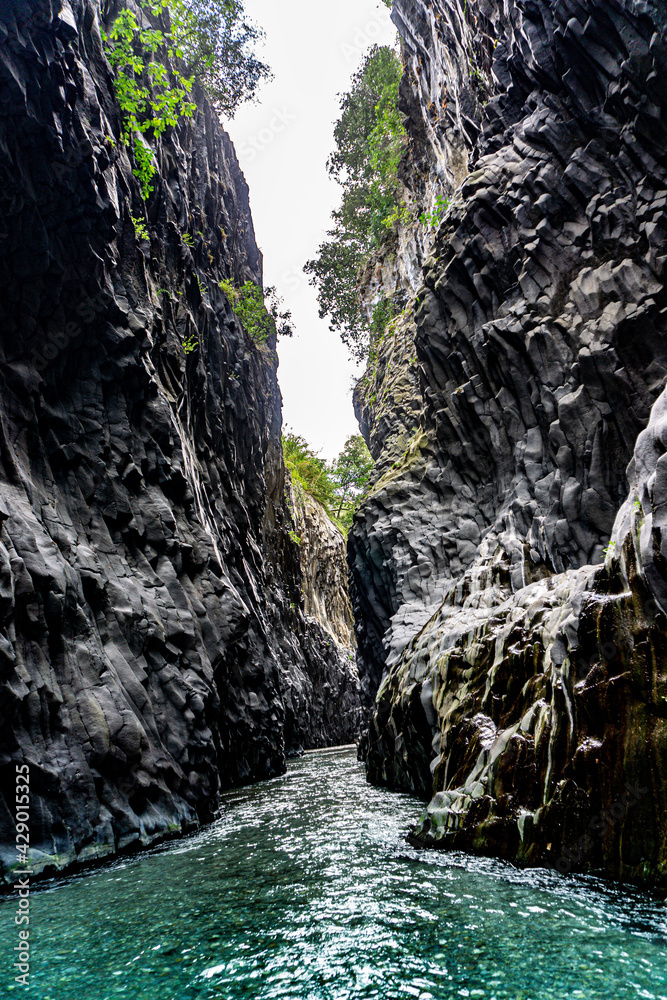 Alcantara river gorge flowing among basalt geological formations in ...