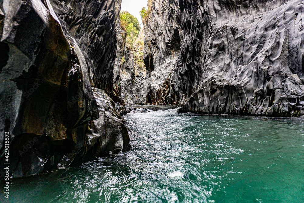 Alcantara river gorge flowing among basalt geological formations in ...