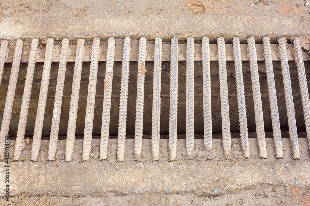 drainage channel with a grate of iron rods rebar dirty in a swamp ...
