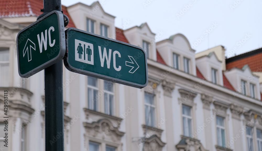 WC sign, logo of public toilets in the street against building ...