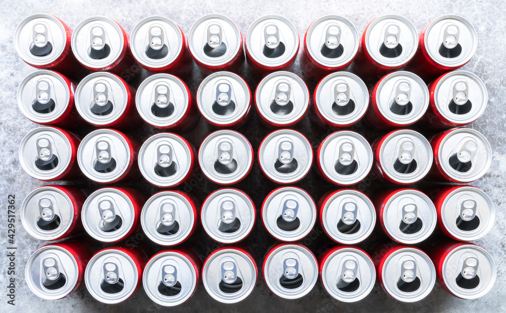 Top view, many aluminum soft drink can lay in a roll patrern alignment ...