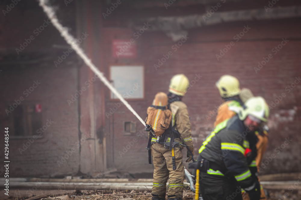 Firefighters put out large massive fire blaze, group of fire men in ...